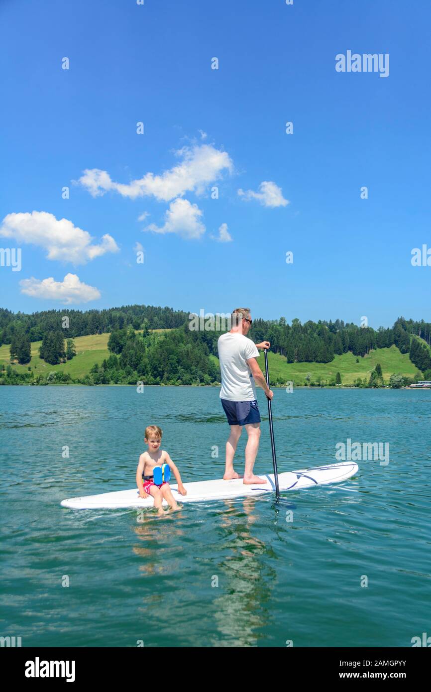 A lot of fun on sup board with the little son Stock Photo - Alamy
