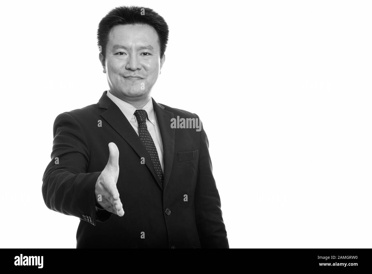 Studio shot of Japanese businessman giving handshake Stock Photo - Alamy