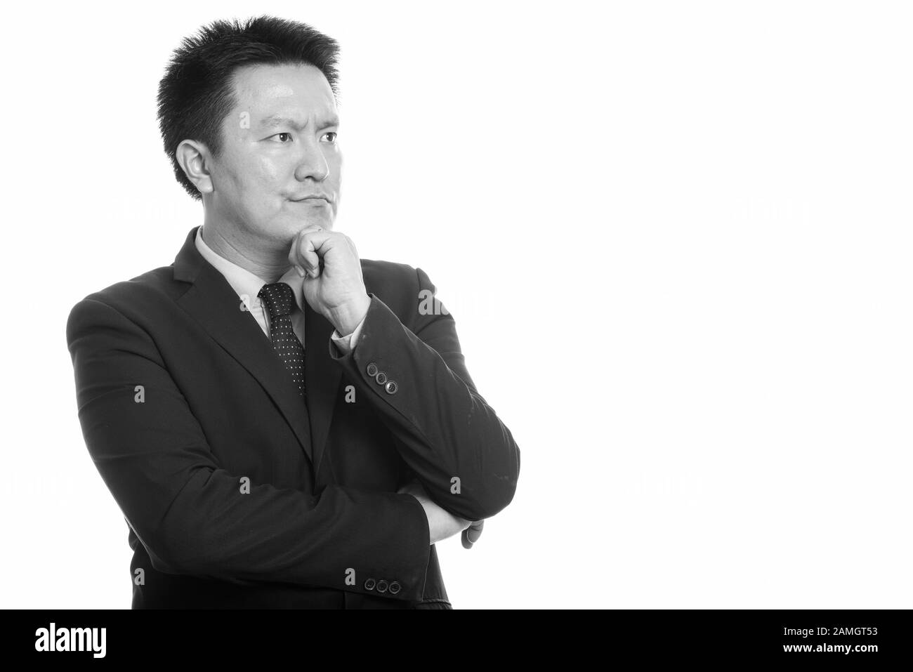 Studio shot of Japanese businessman thinking in black and white Stock ...
