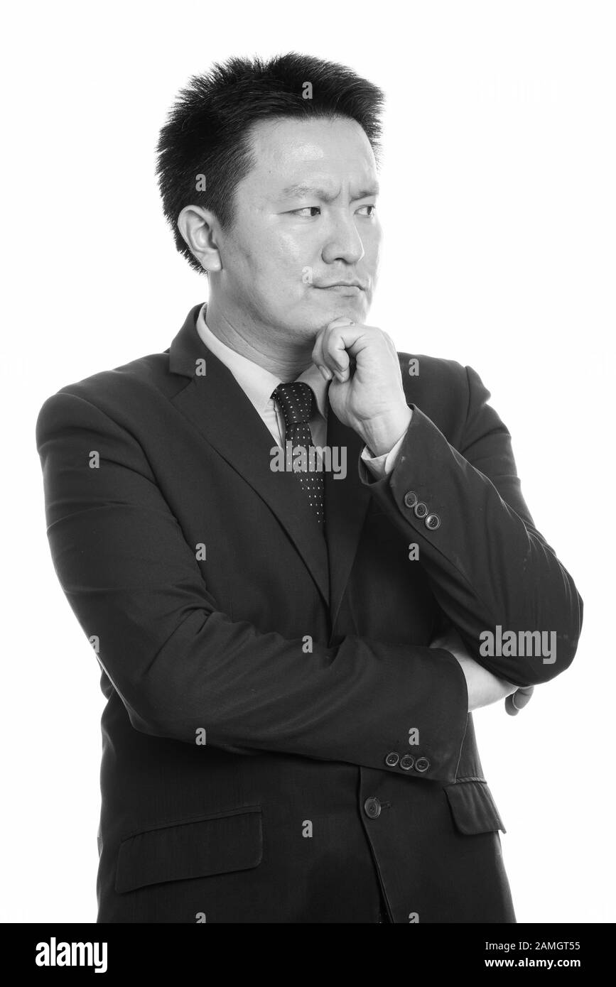 Studio shot of Japanese businessman thinking in black and white Stock ...
