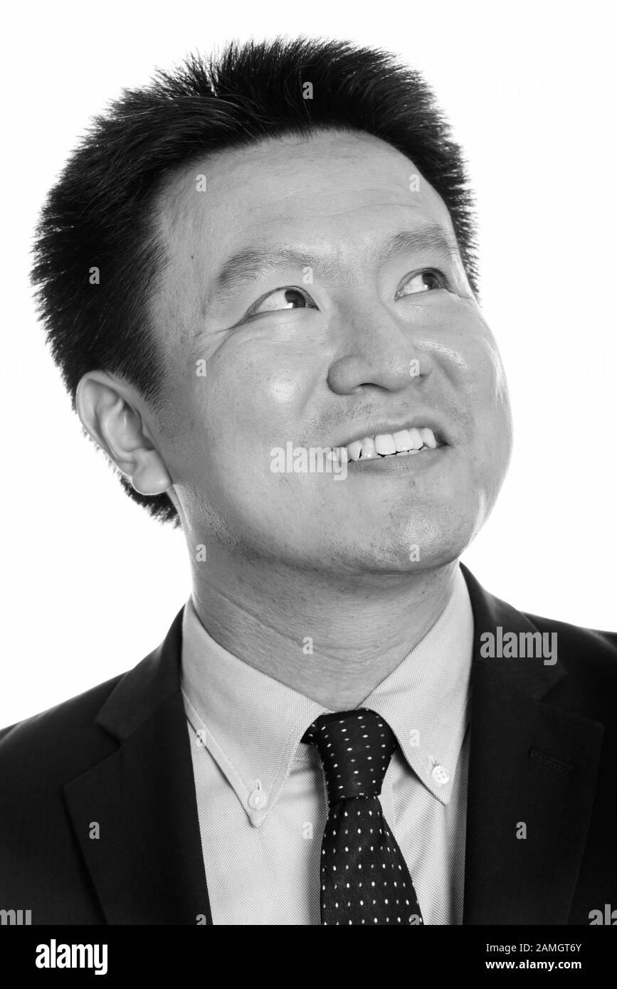 Face of happy Japanese businessman smiling and thinking Stock Photo - Alamy
