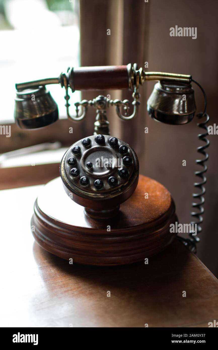 Closeup of wooden and brass antique dial telephone on room table ...