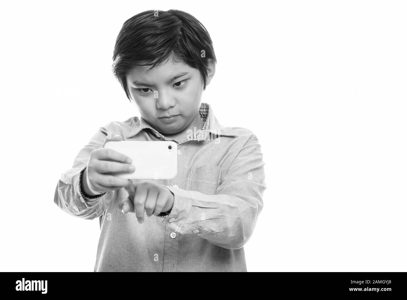 Studio shot of cute Japanese boy taking picture with mobile phone Stock ...