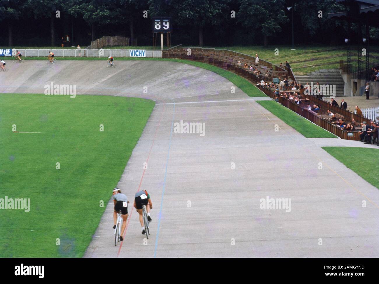 Aerial view of two cyclists racing around a curved track with ...