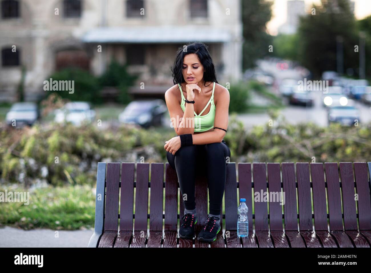 Fitness woman standing and taking break on bench Stock Photo - Alamy