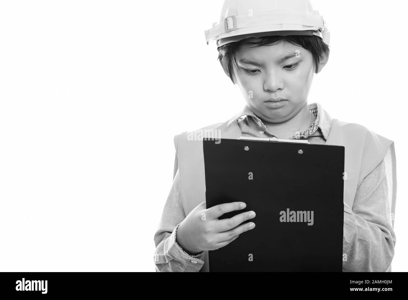 Studio shot of cute Japanese boy construction worker reading on ...