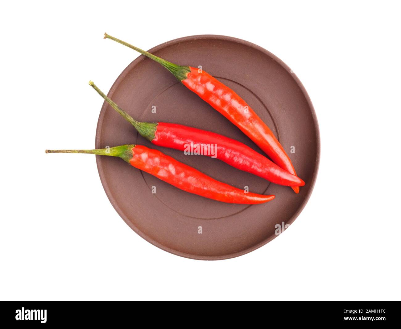 Red chili pods on clay plate on white isolated background. Indian ...
