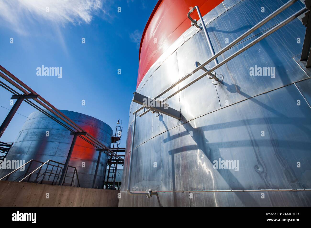 Orange and shiny galvanized steel storage tanks with sulfuric acid on ...