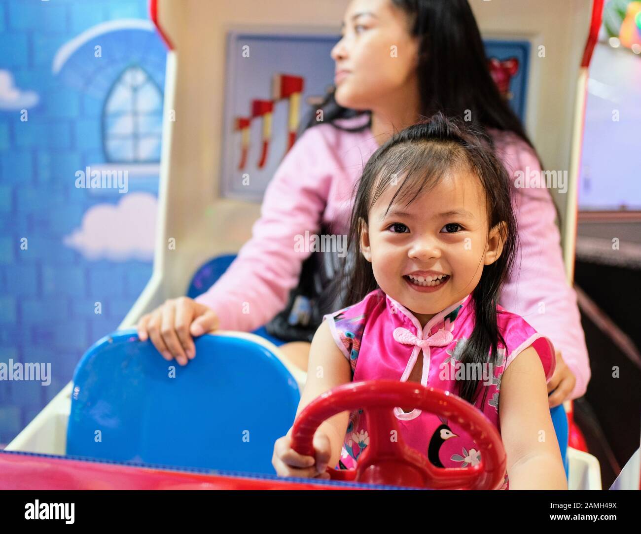 Chinese Girl Kid driving car with her mommy Stock Photo - Alamy