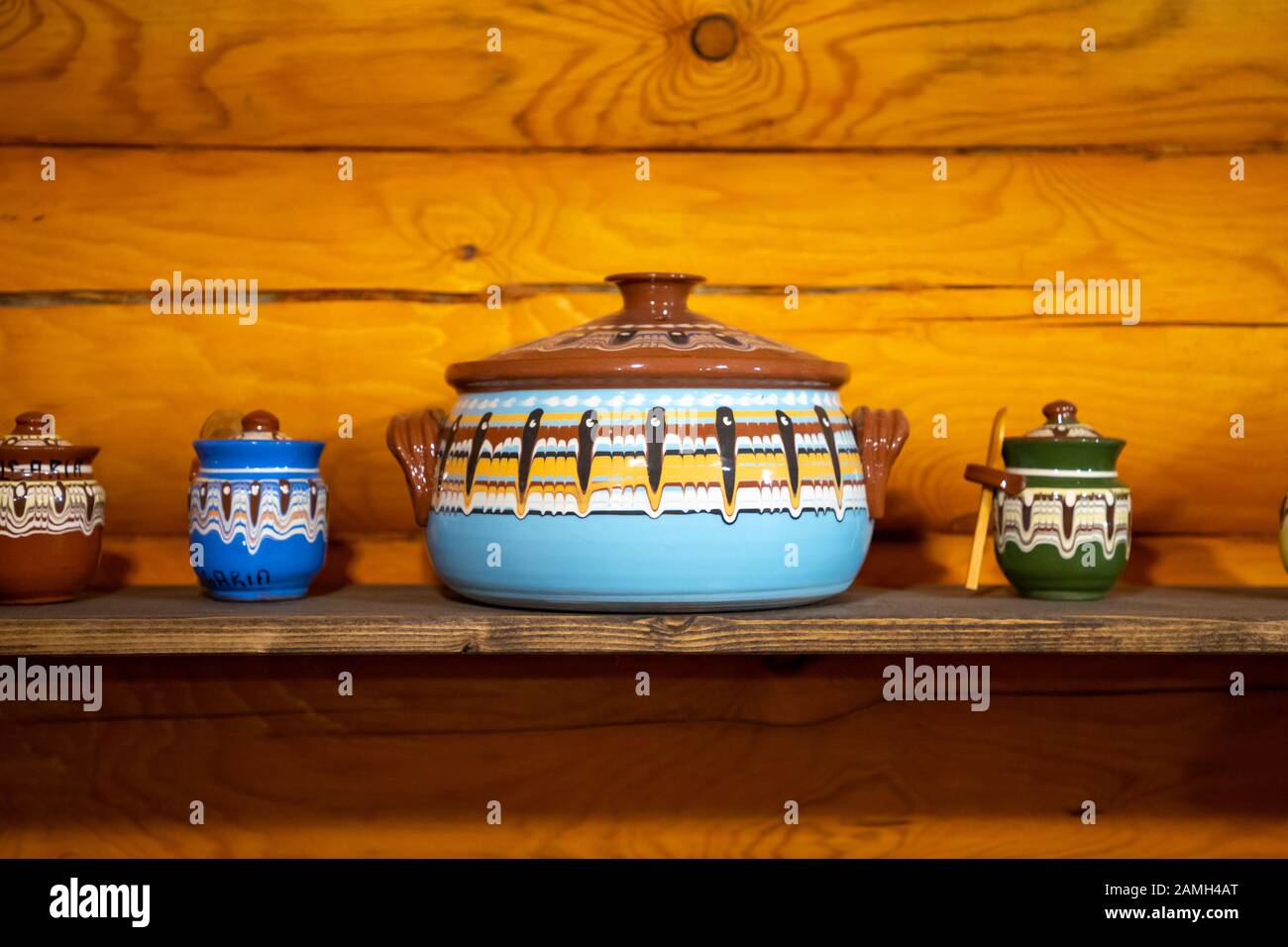 Old fashioned kitchen utensils in Russian folk style on wooden wall ...