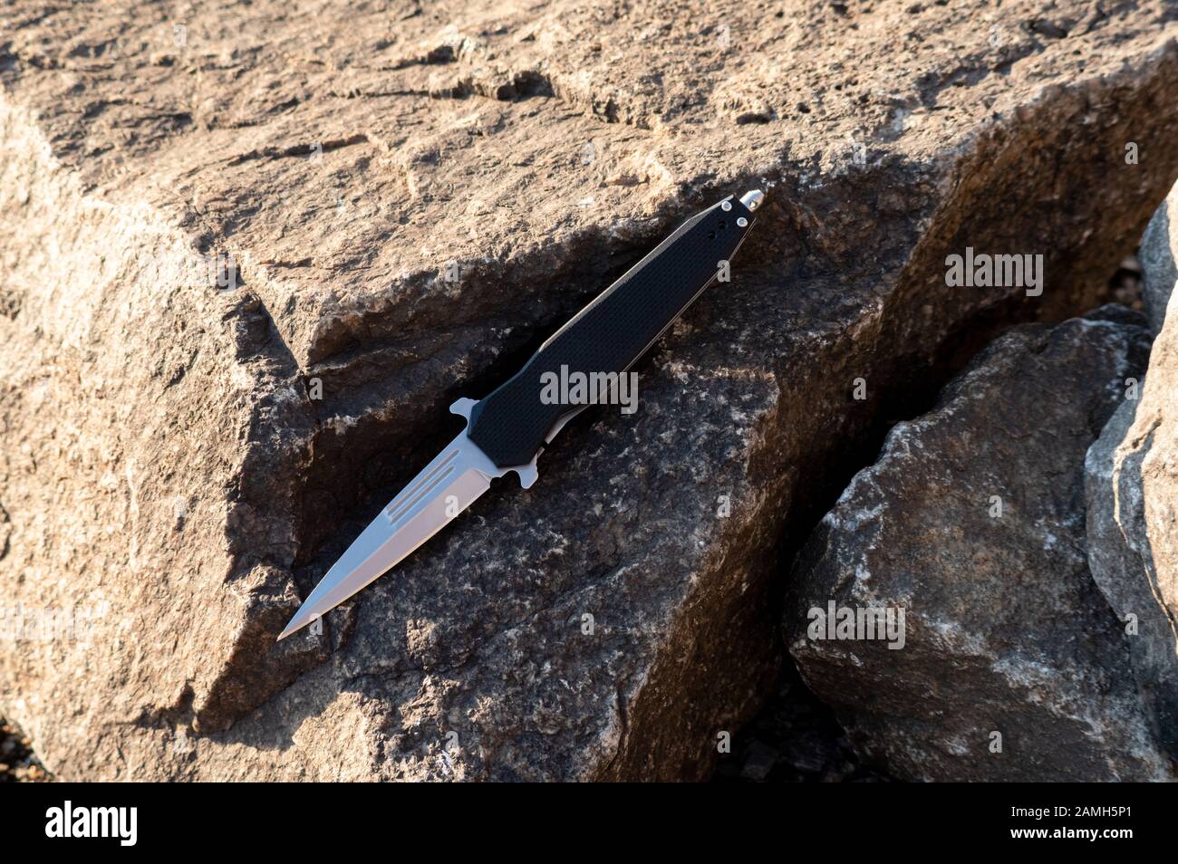 A small dagger against a stone background. A dagger-shaped knife Stock ...