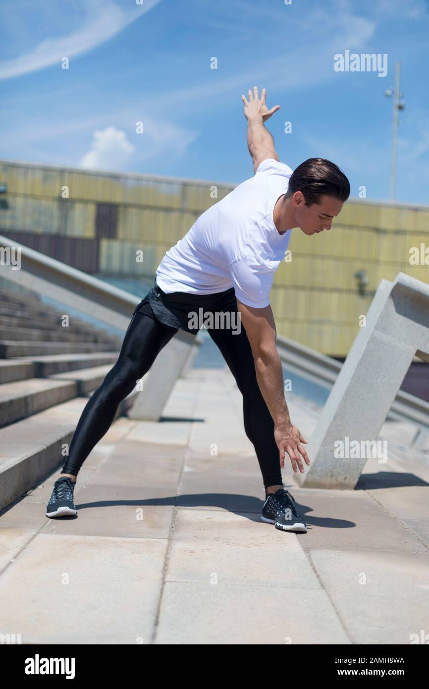 Muscular man stretching outdoors Stock Photo - Alamy