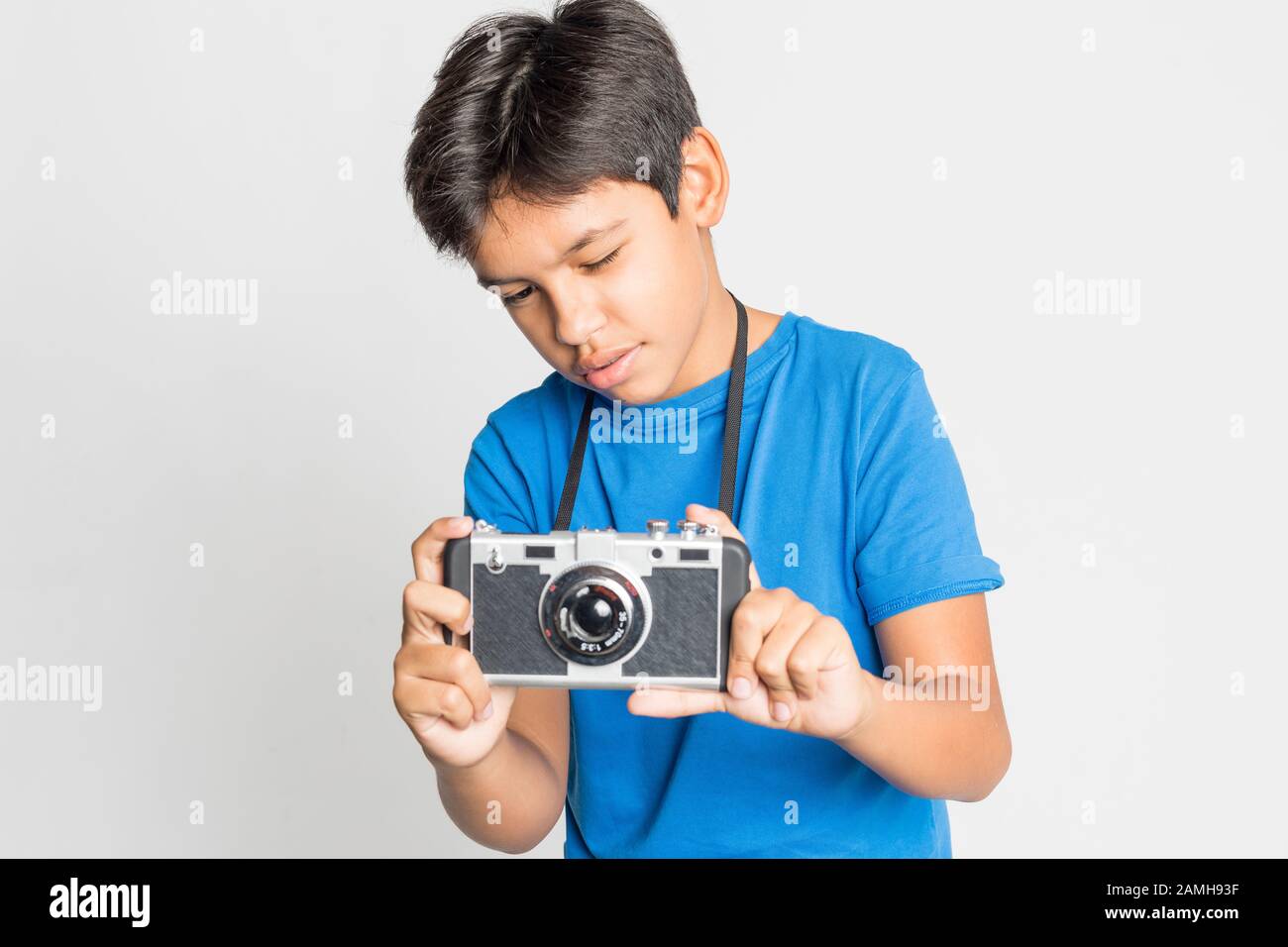 Portrait of a cute young boy with camera isolated on white background ...
