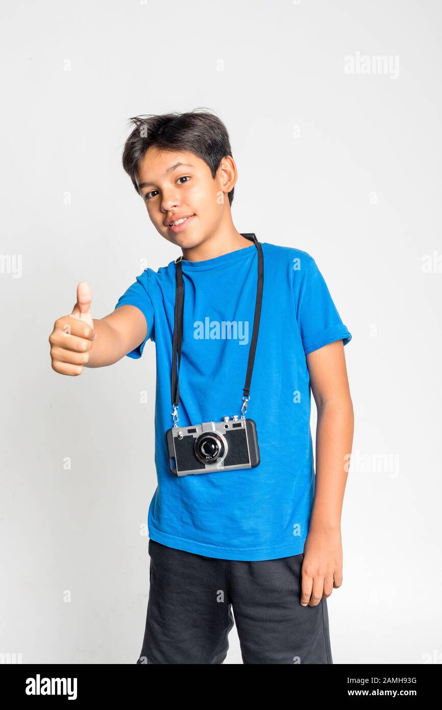 Portrait of a cute young boy with camera isolated on white background ...