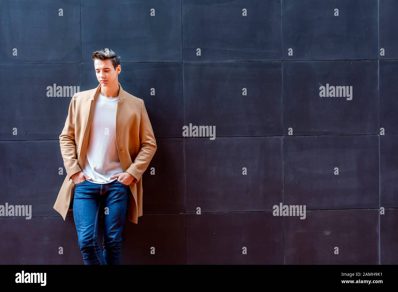Young man wearing winter clothes in the street. Young guy with modern ...