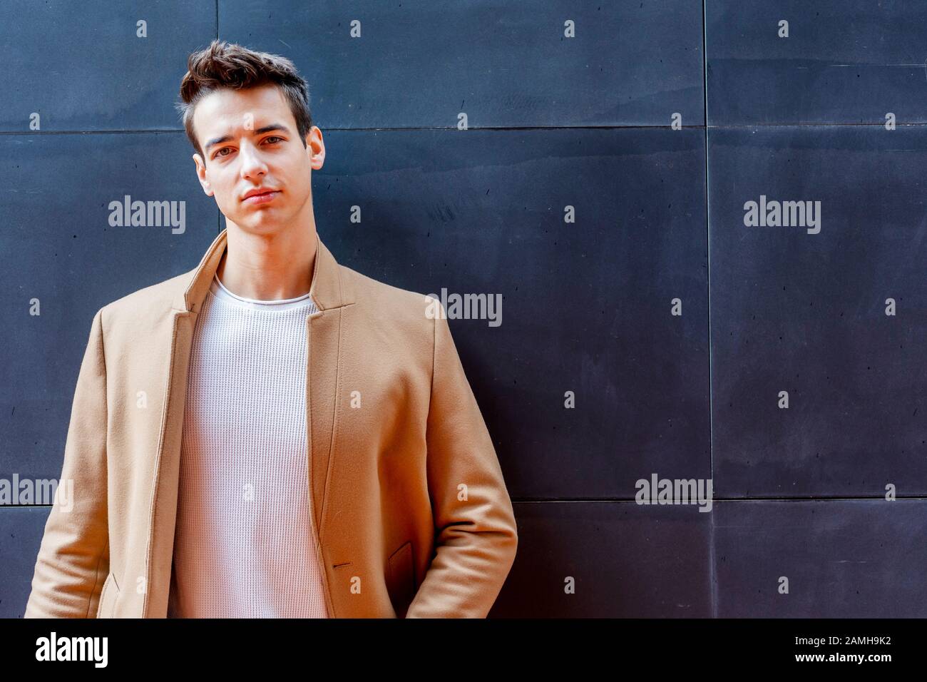 Young man wearing winter clothes in the street. Young guy with modern ...