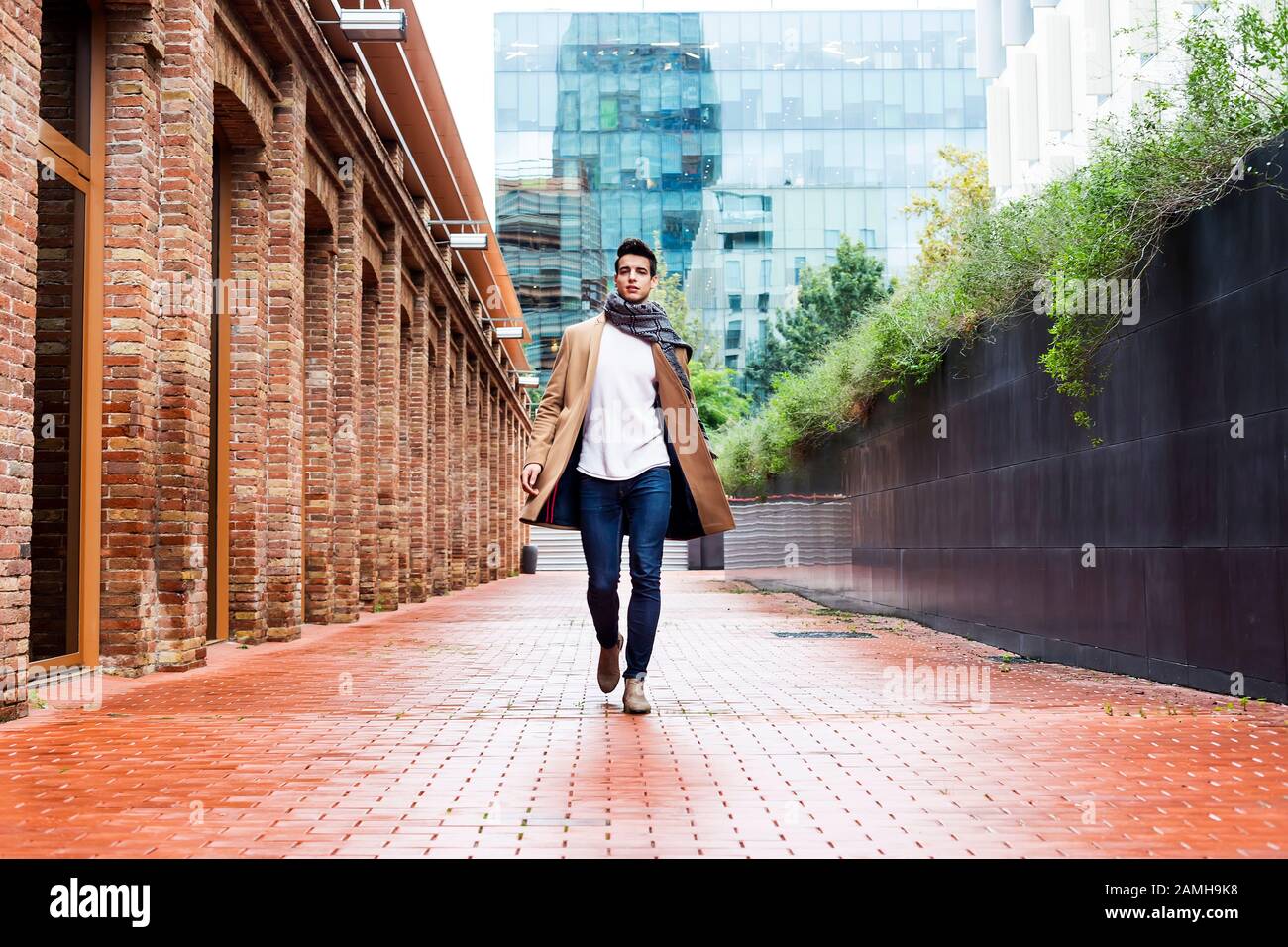 Young man wearing winter clothes in the street. Young guy with modern ...