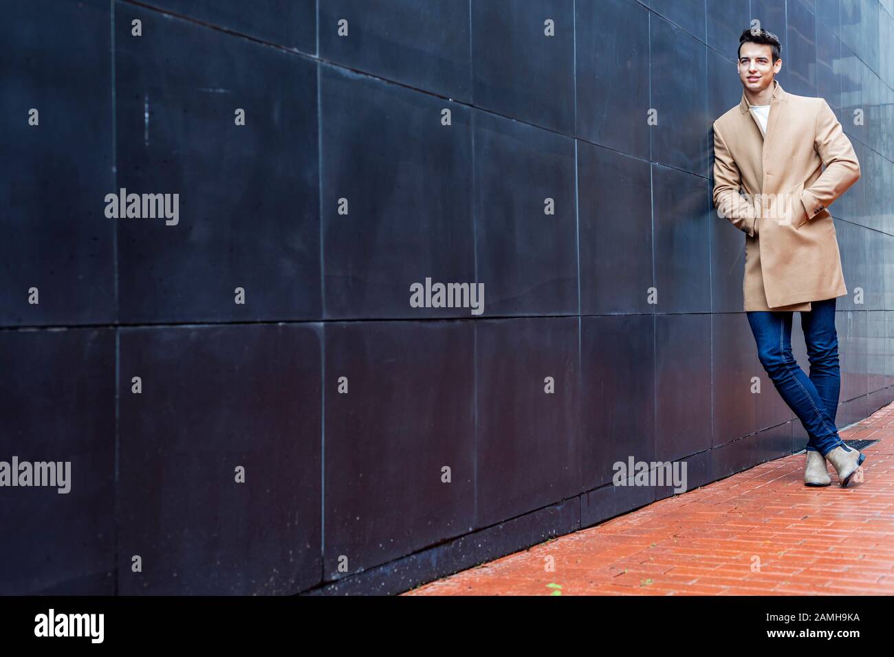 Young man wearing winter clothes in the street. Young guy with modern ...