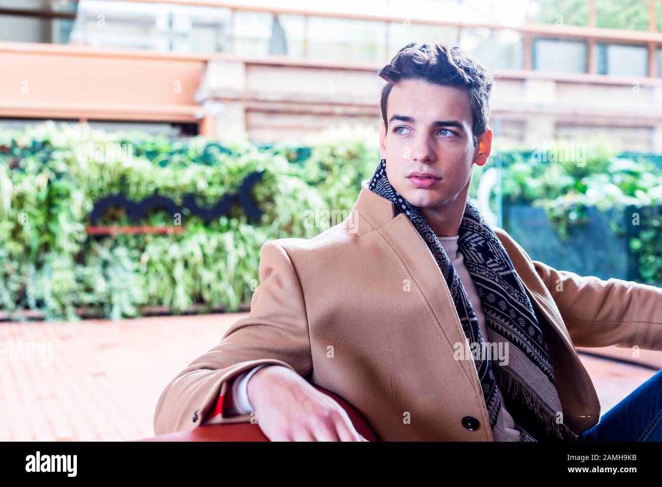 Young man wearing winter clothes in the street. Young guy with modern ...
