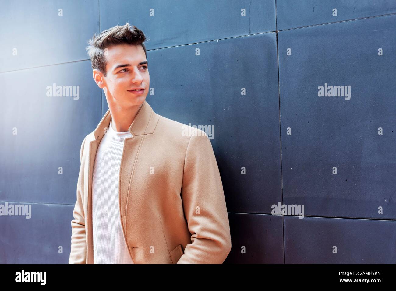 Young man wearing winter clothes in the street. Young guy with modern ...