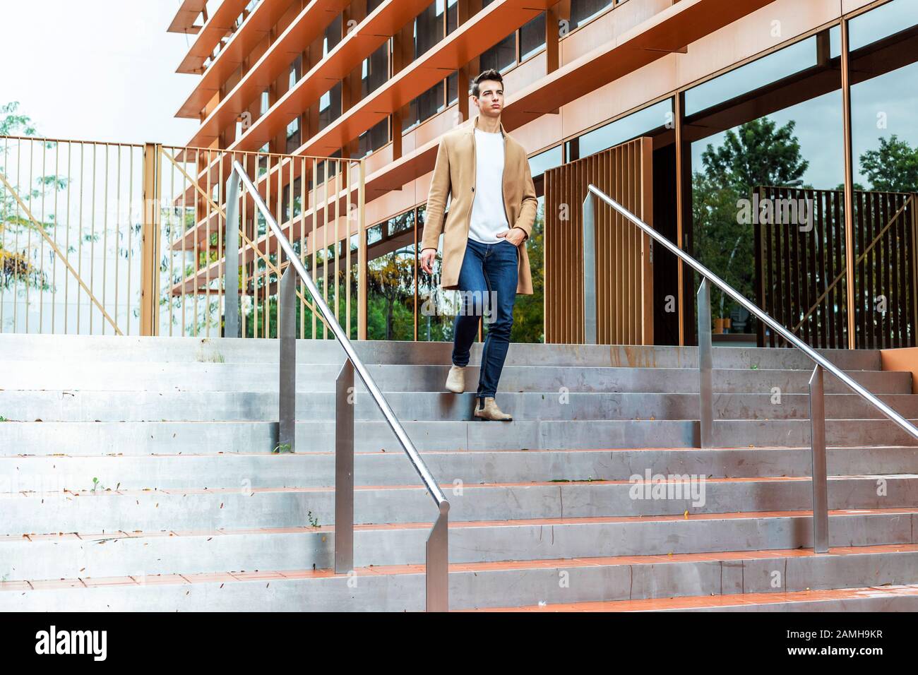 Young man wearing winter clothes in the street. Young guy with modern ...