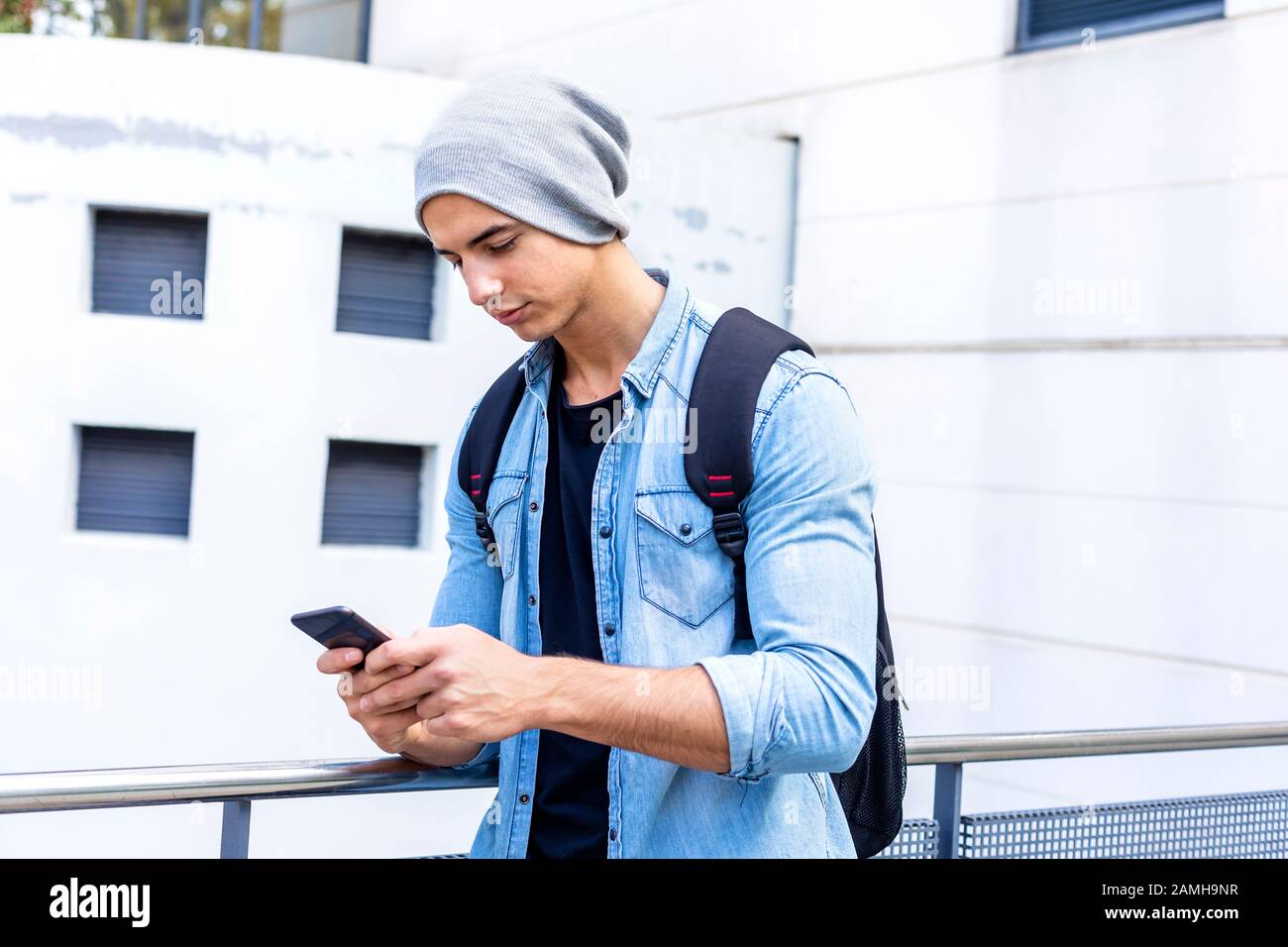 Typing text message. Side view of handsome young man in smart casual ...