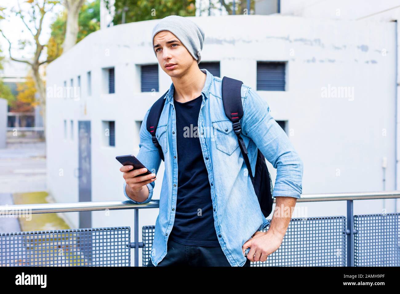 Typing text message. Side view of handsome young man in smart casual ...