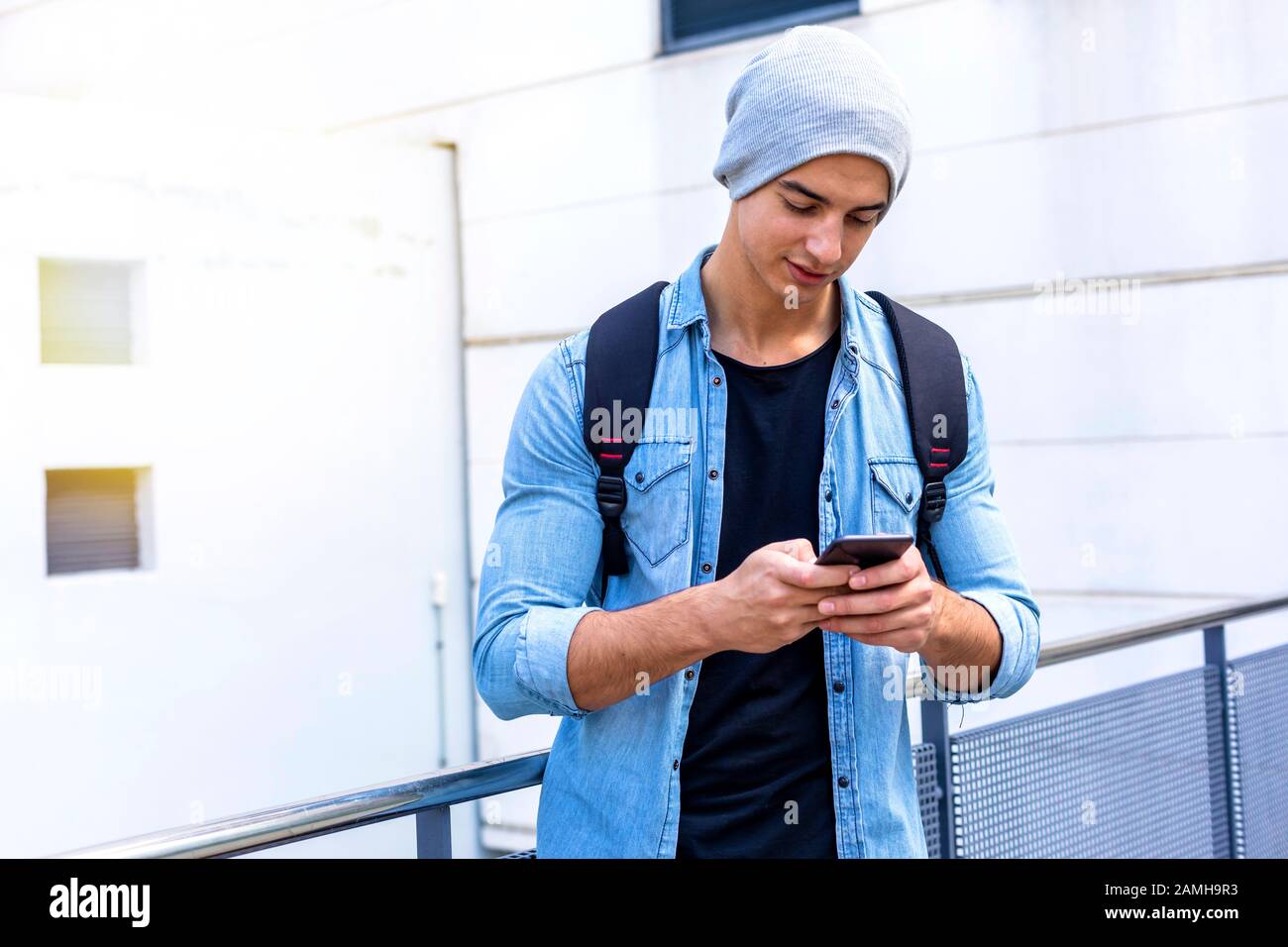 Typing text message. Side view of handsome young man in smart casual ...