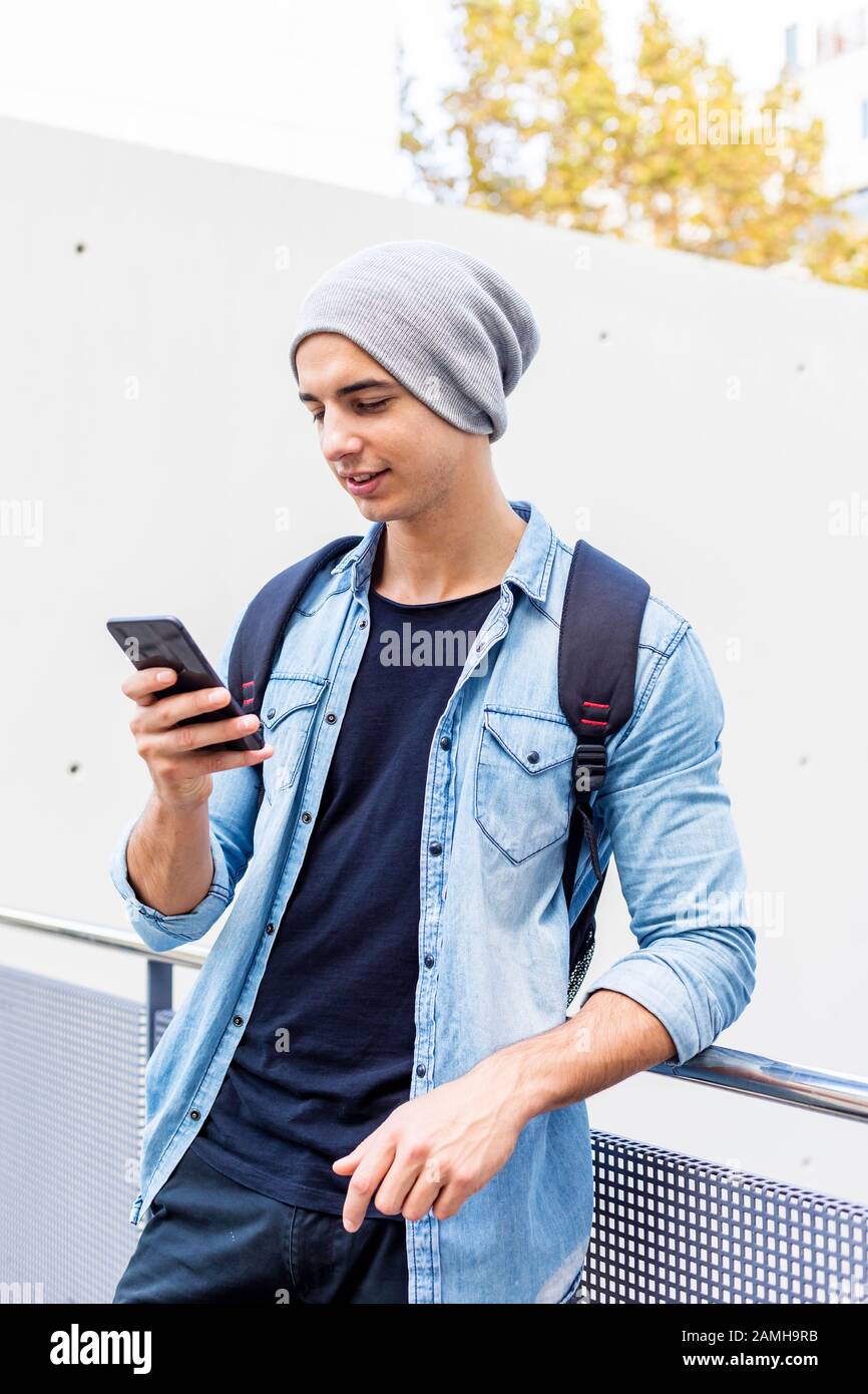 Typing text message. Side view of handsome young man in smart casual ...