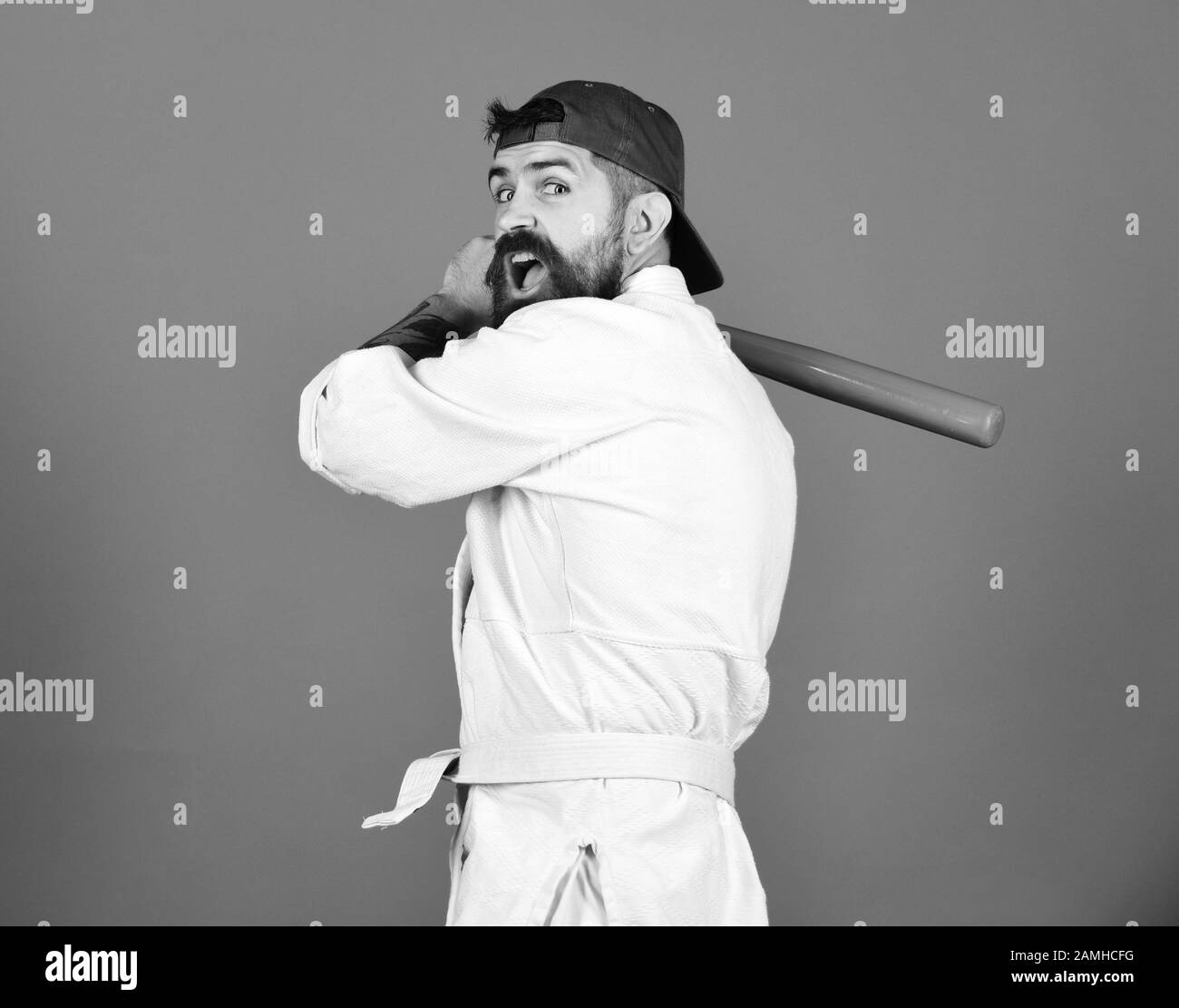 Athlete gets ready to fight. Man with beard in white kimono and green ...