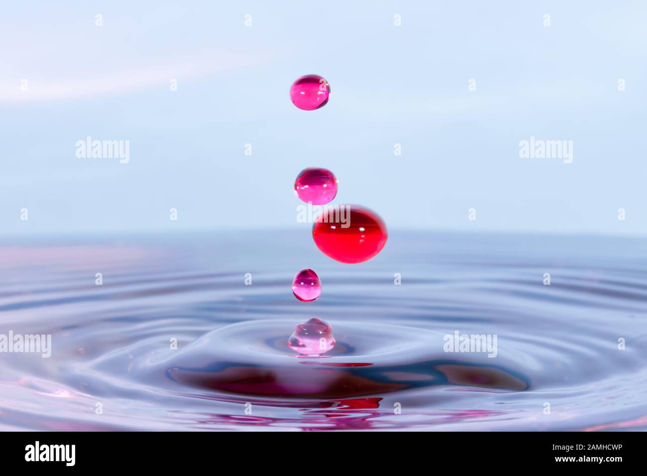High speed water drop photograph with red colored falling drops Stock ...