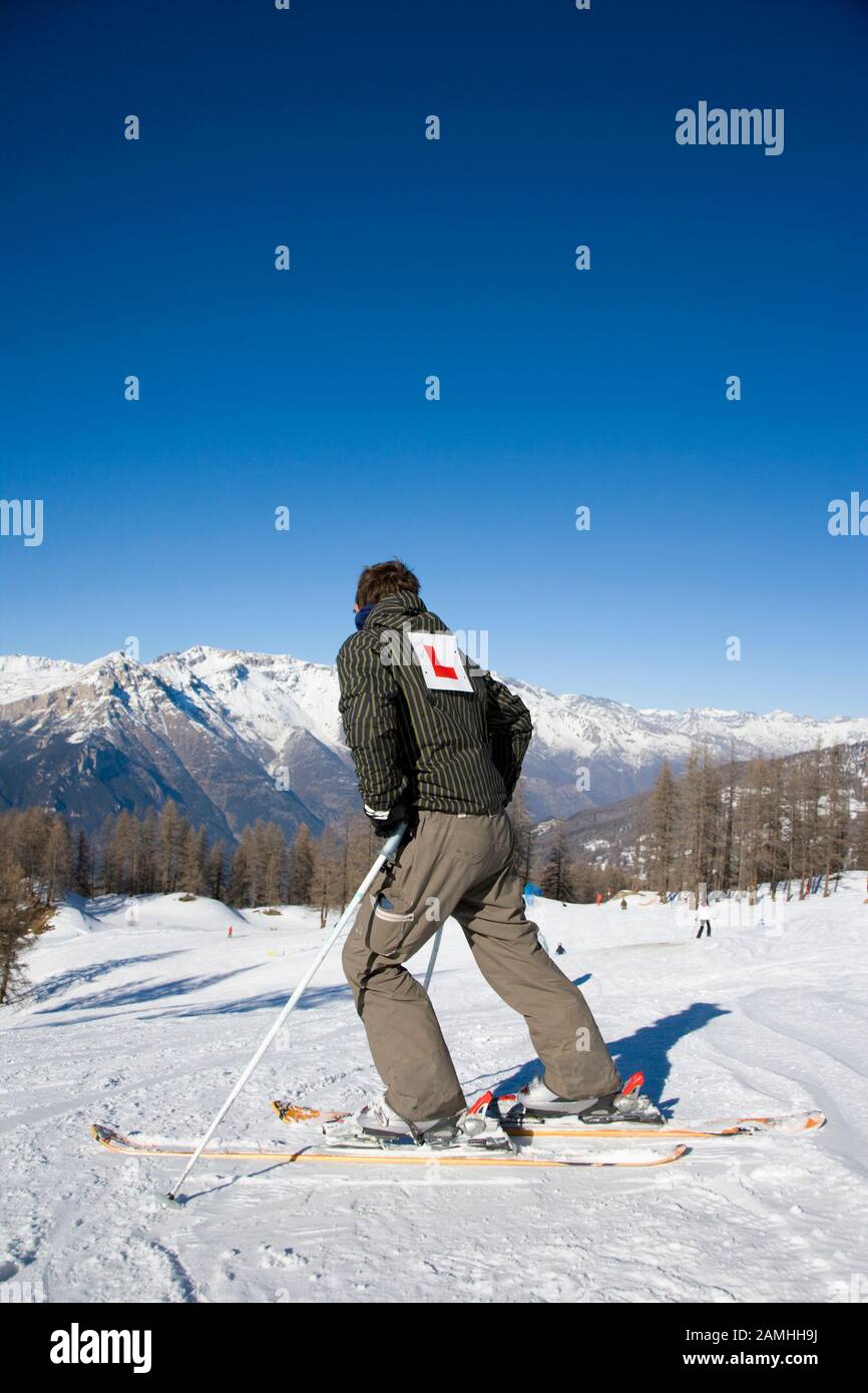 Italy, Piemonte, Milky Way, skier with L palte on back standing on hill ...