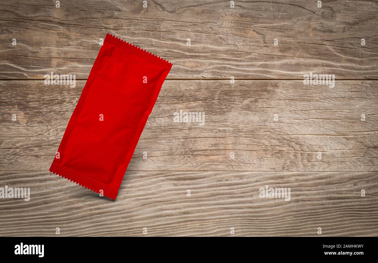 Blank Red Condiment Packet Floating on Aged Wood Background Stock Photo ...