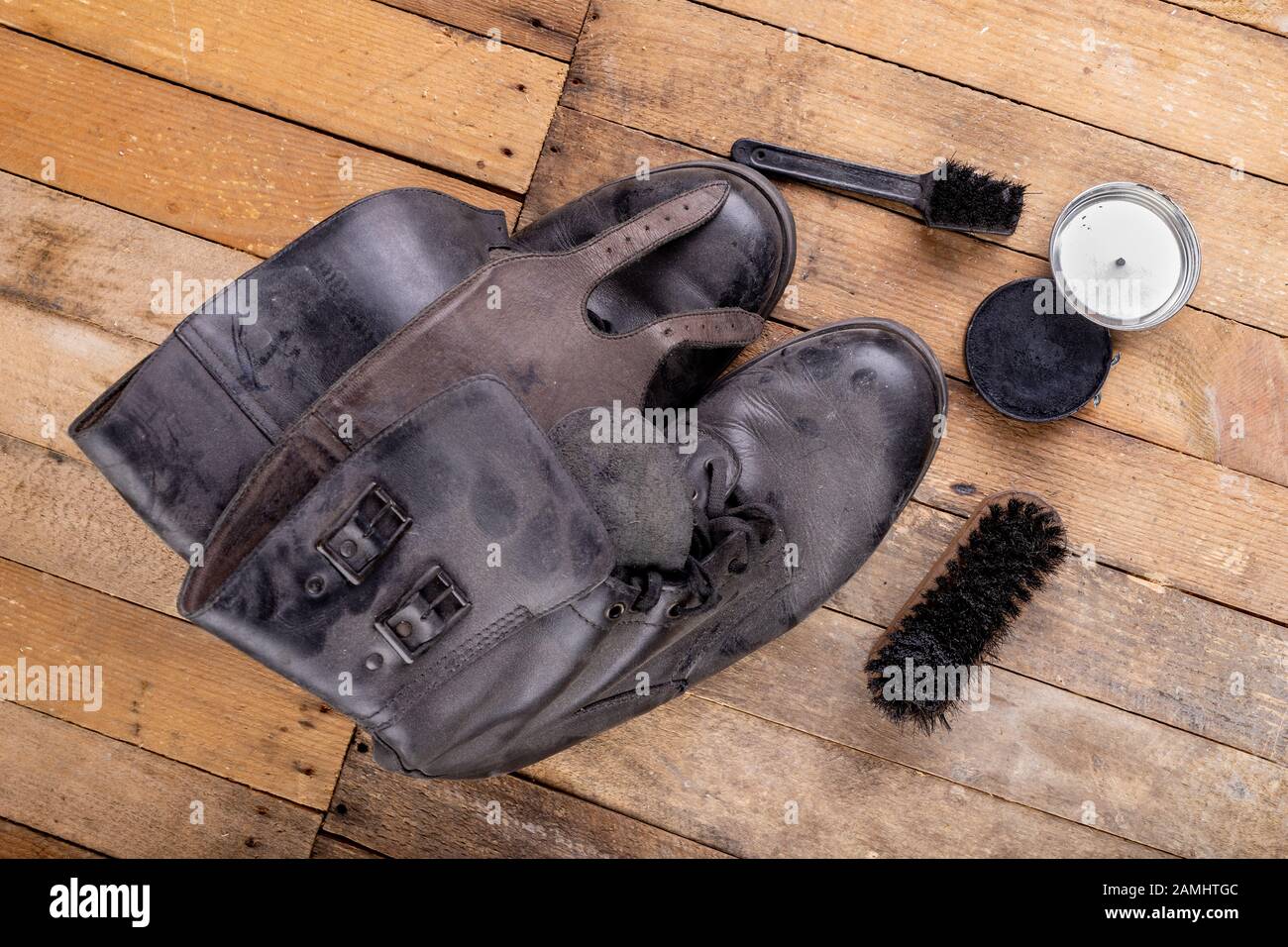 Polishing of military boots on a wooden table. Maintenance and ...