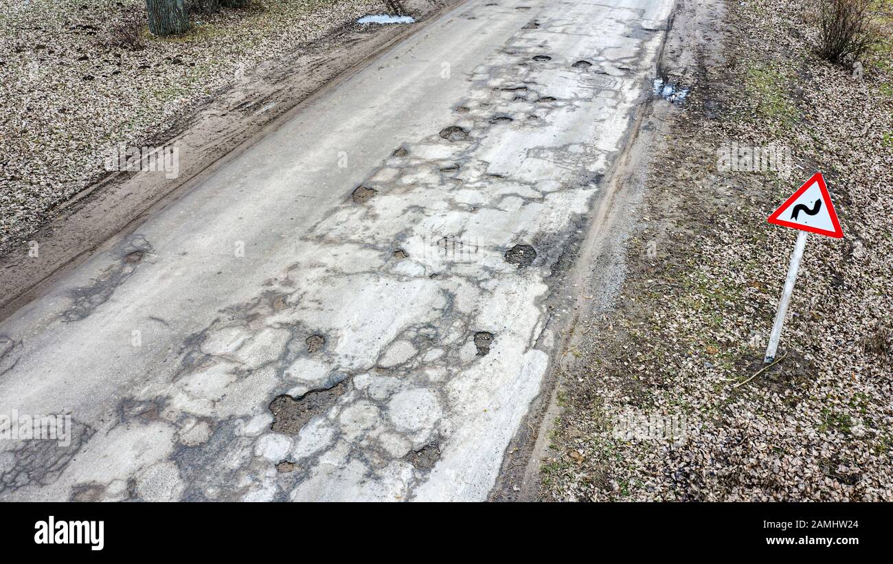 Large pits are filled with water on an asphalt road Stock Photo - Alamy