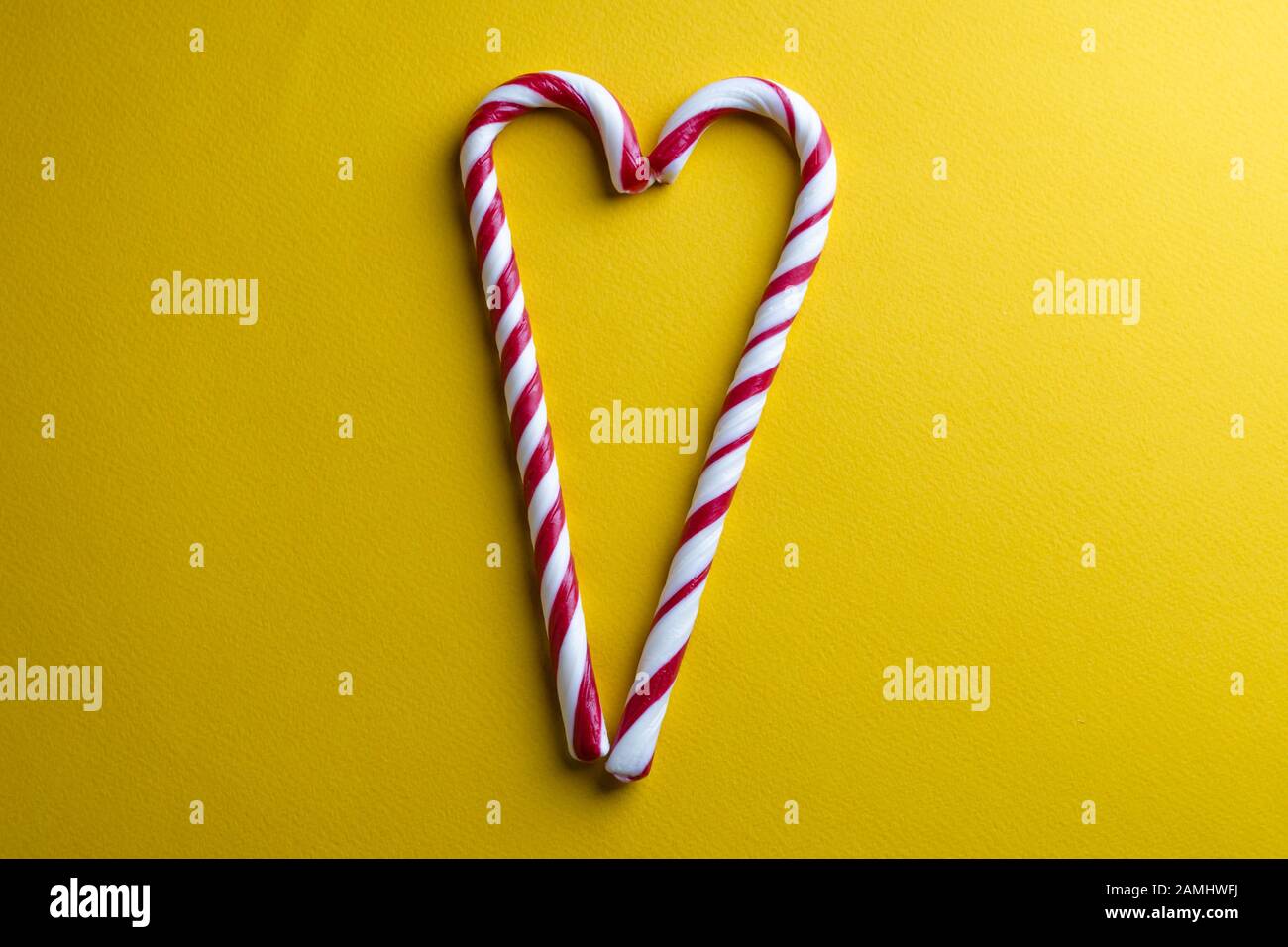 Peppermint candy canes on a yellow background Stock Photo - Alamy