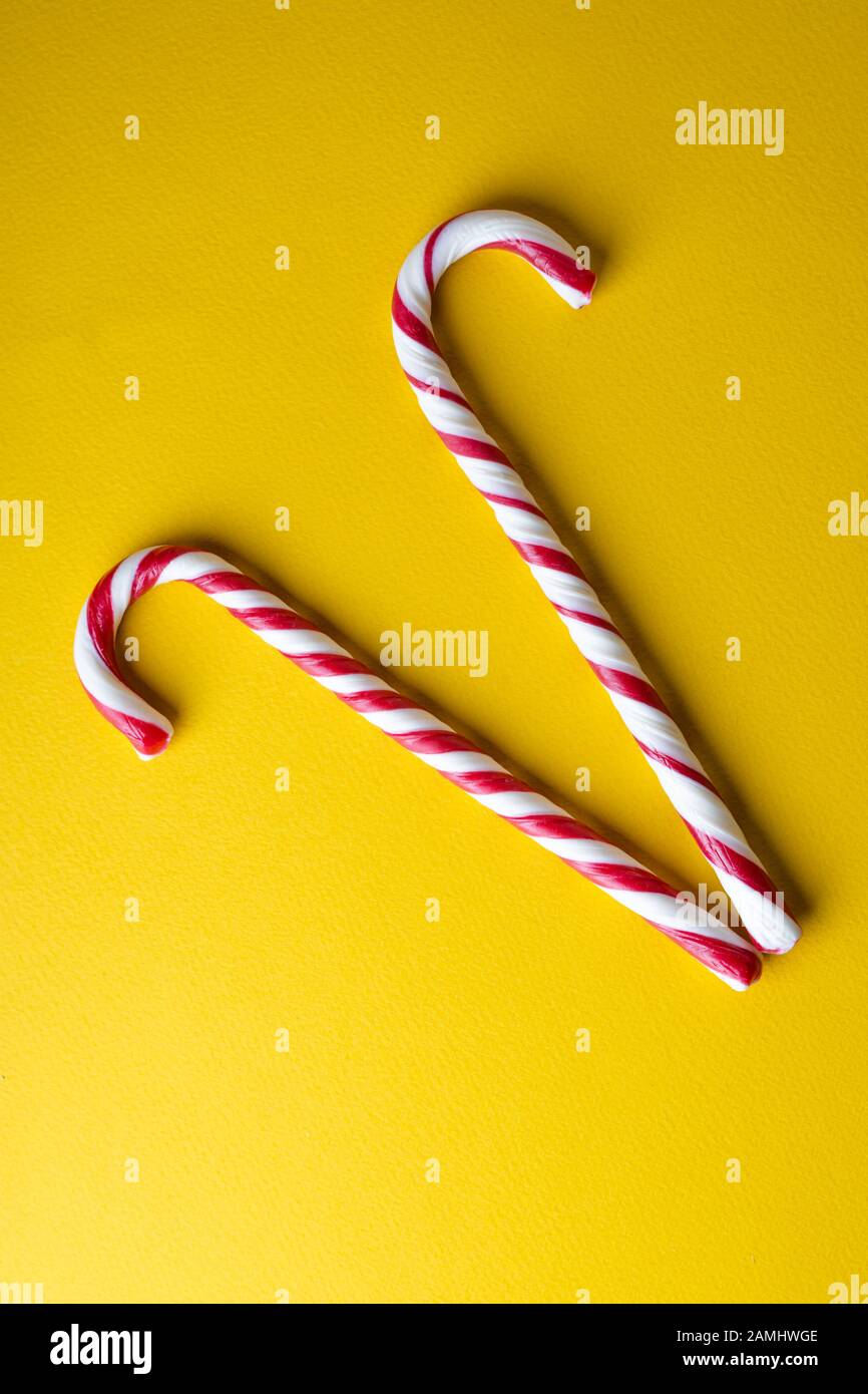 Peppermint candy canes on a yellow background Stock Photo - Alamy
