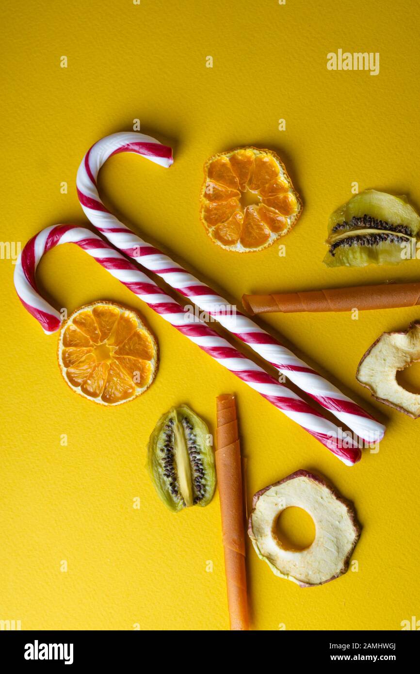 Peppermint candy canes with dried fruits on a yellow background Stock ...