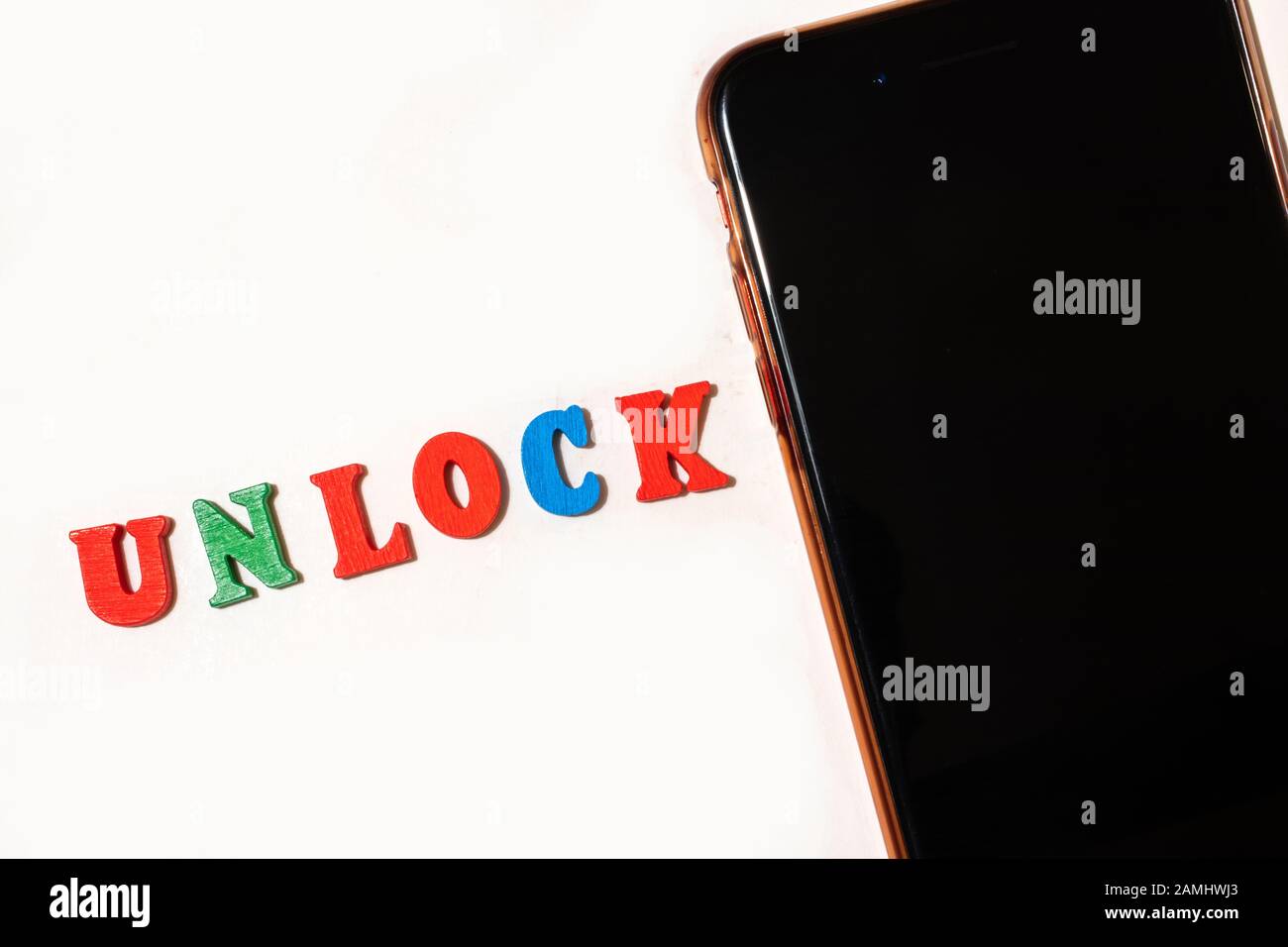 Phone with word unlock on white background flat lay Stock Photo - Alamy