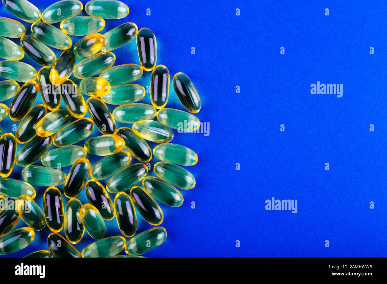 Omega 3. Fish oil capsules on blue background and texture, vitamin D ...