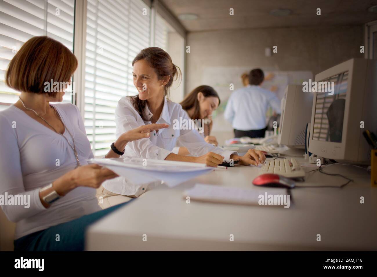 Businesswomen working at their desks inside an office Stock Photo - Alamy