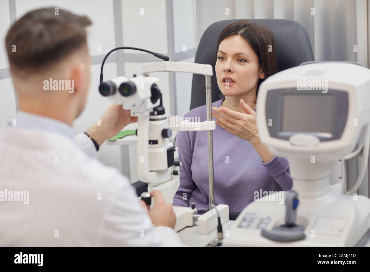 Portrait of male ophthalmologist using ophtalmic refractometer during ...