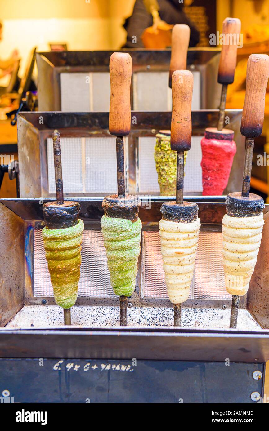 Cooking Trdelnik, a traditional cone-shaped puff pastry snack cooked on ...