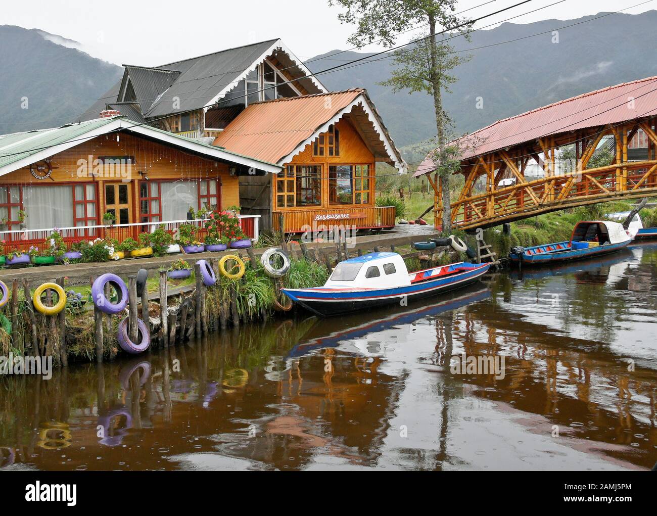 Colorful boats and restaurants on a canal in the village of Encano ...