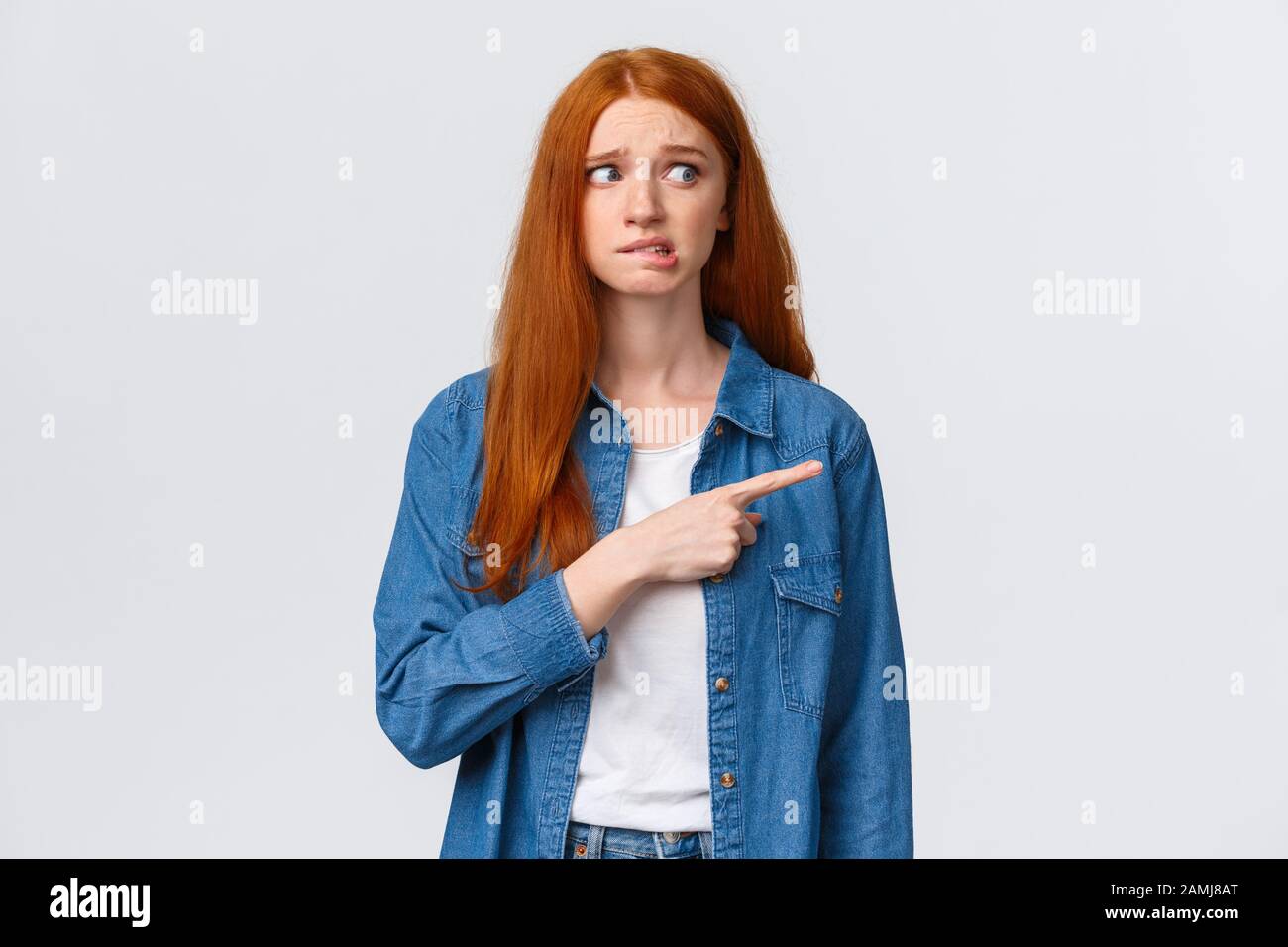Awkward and nervous cute timid redhead teenage girl having fear or ...