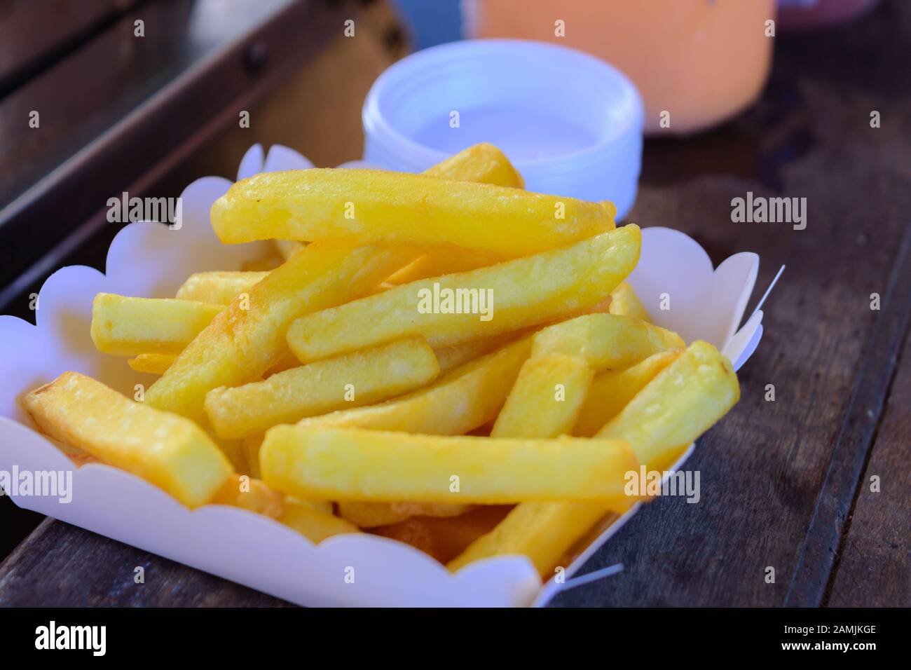 Fresh french fries in a paper container on wood table Stock Photo - Alamy