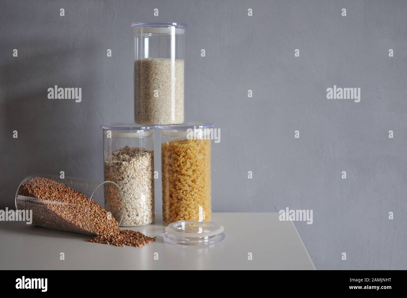 Various uncooked cereals for healthy cooking in a glass jars on grey ...