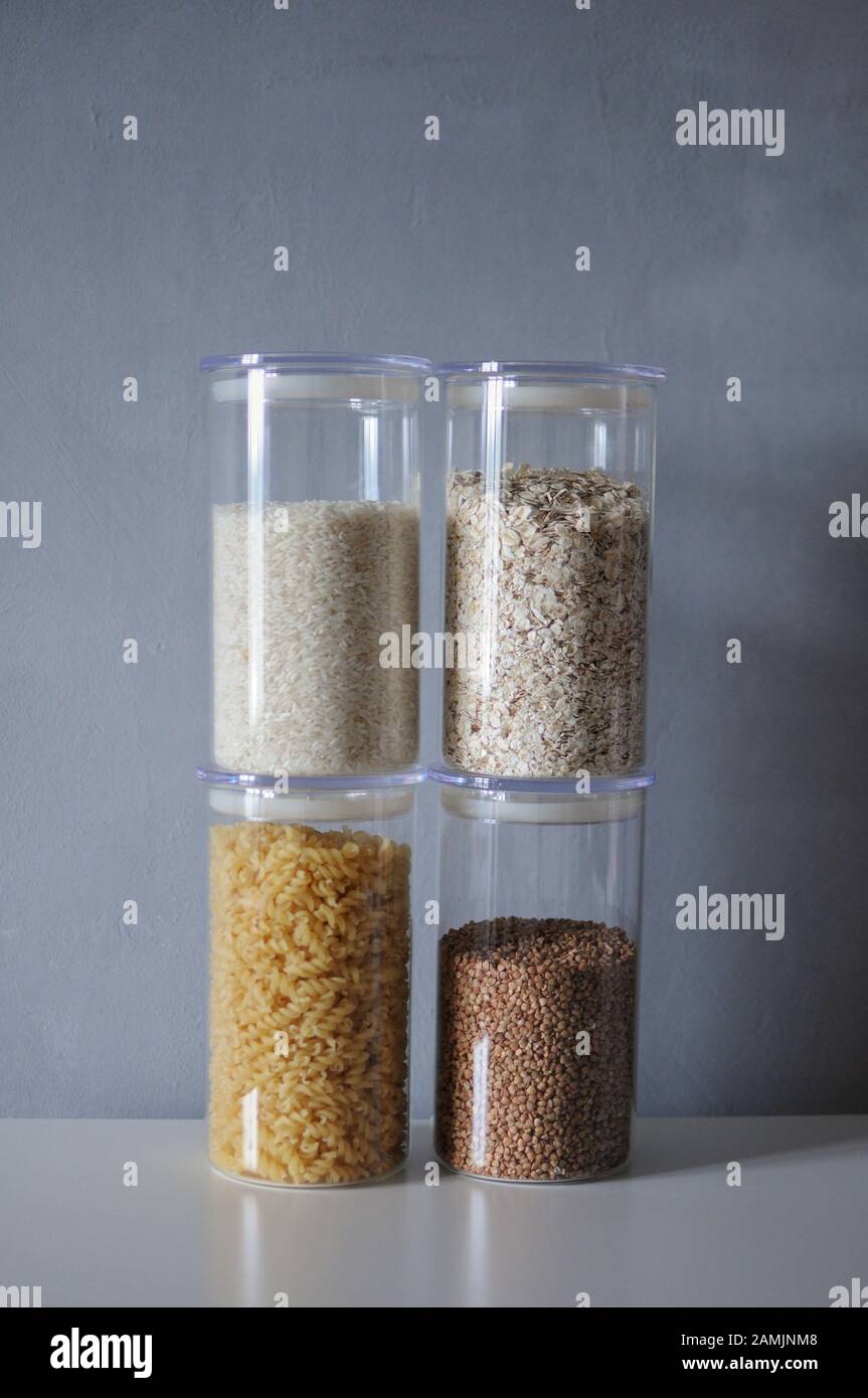 Set of various uncooked cereals in a glass jars on grey background ...
