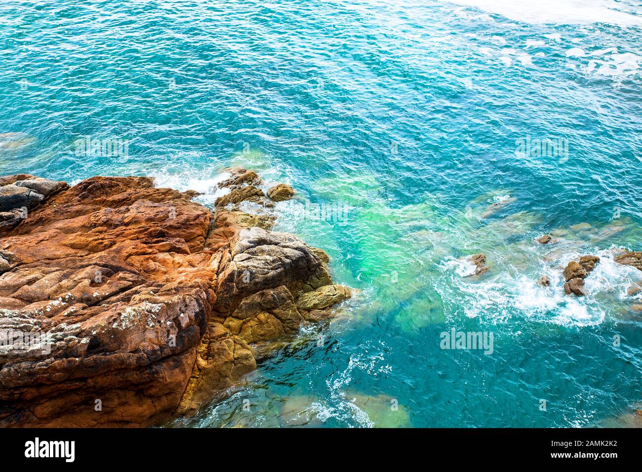 top view of big rock emerging from the ocean with strong waves Stock ...