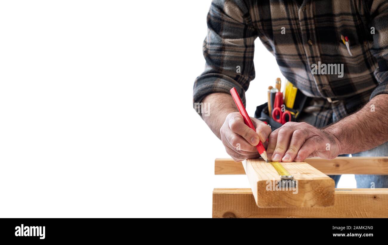 Close-up. Carpenter with pencil and the meter marks the measurement on ...